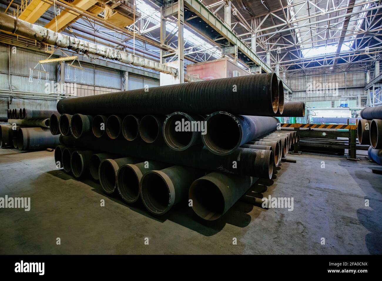 New cast iron pipes for pipeline construction in warehouse Stock Photo ...