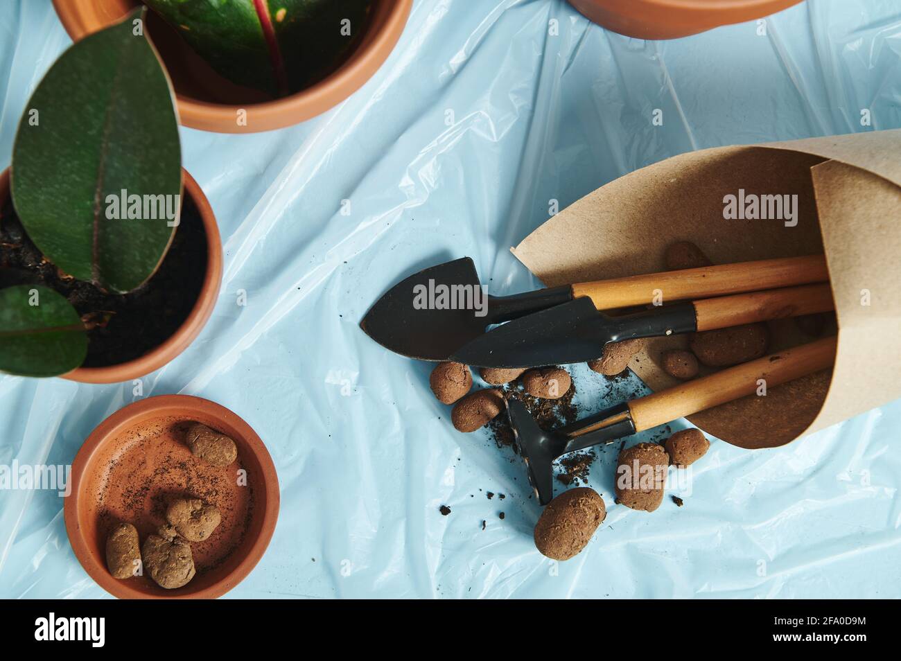 Scattered expanded clay for plants with a set of garden tools, wrapped ...