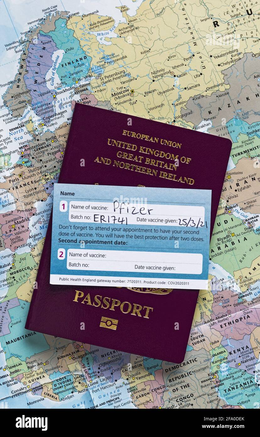 Pfizer vaccine card with passport on world map Stock Photo - Alamy