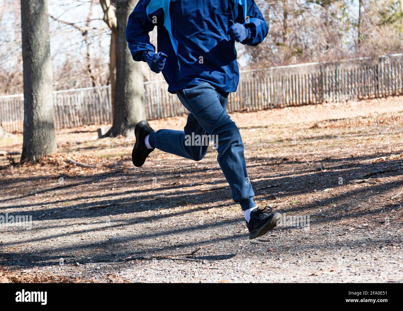 A high school track runner running up a hill for strength work at ...