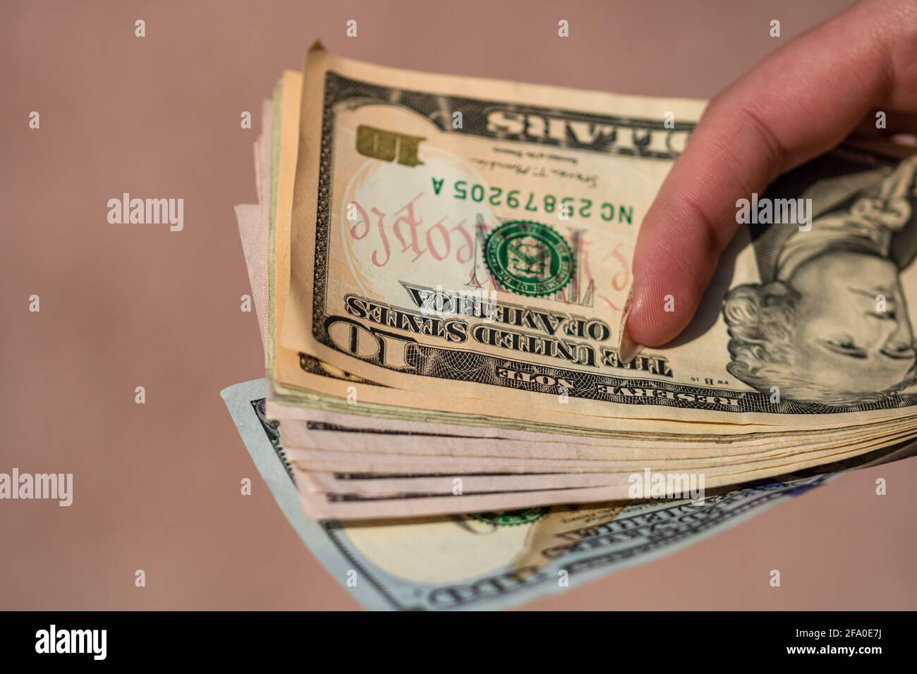 Closeup of a female hand giving USD banknotes - world money, inflation ...