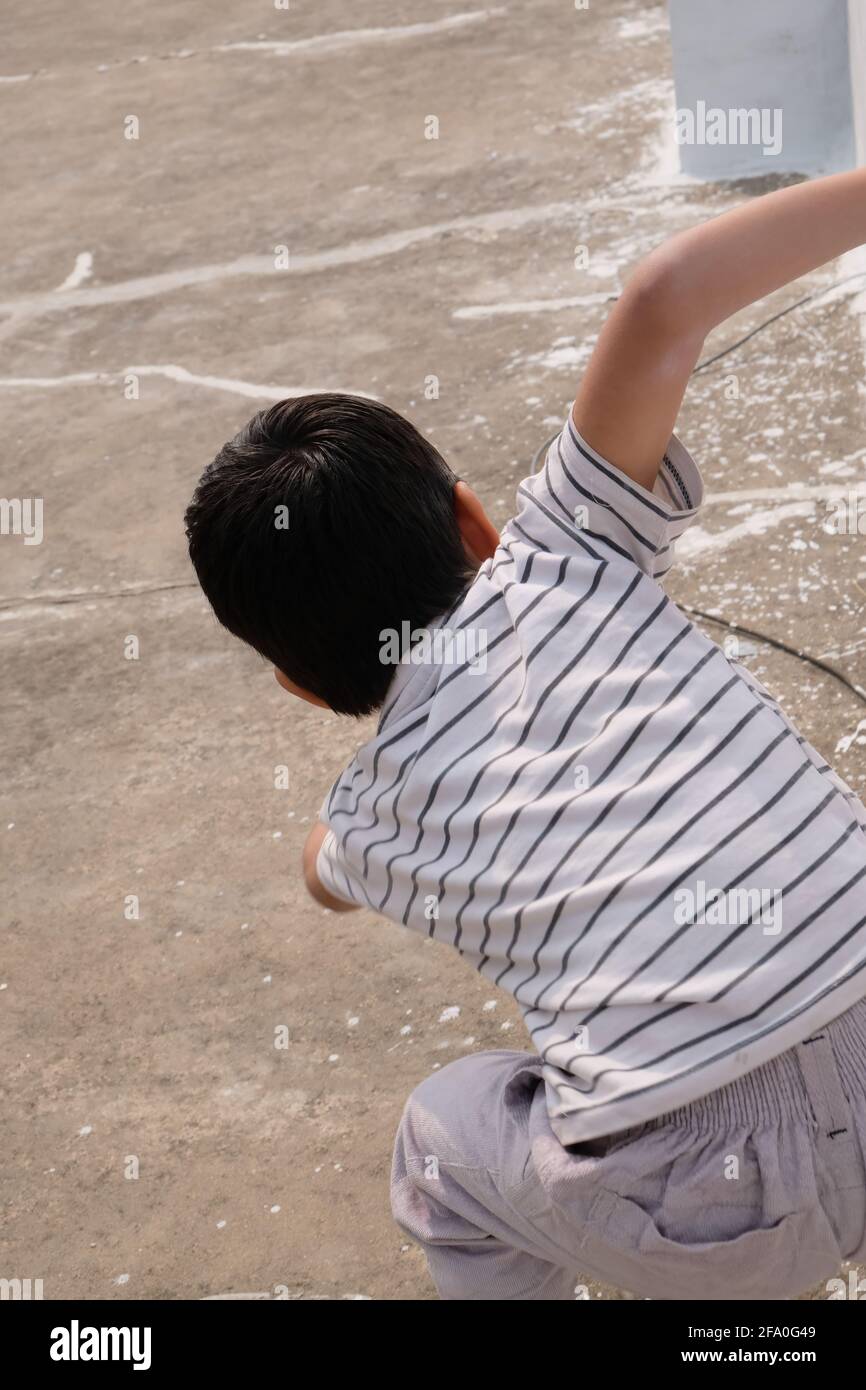 Shallow focus of an Indian kid running and playing outdoors on a sunny ...