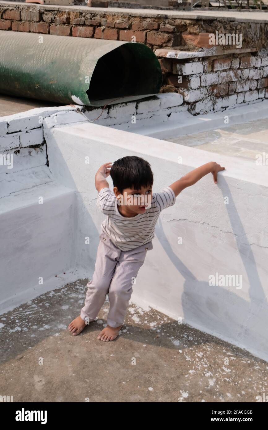 Shallow focus of a young Indian kid playing on a building roof on a ...