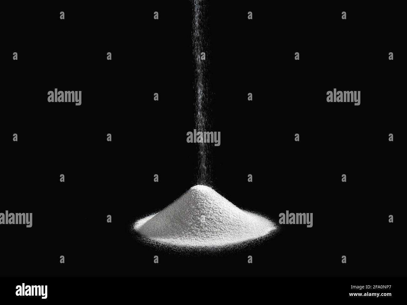 Coarse ground pumice, lit to show maximum texture, falling into a pile ...