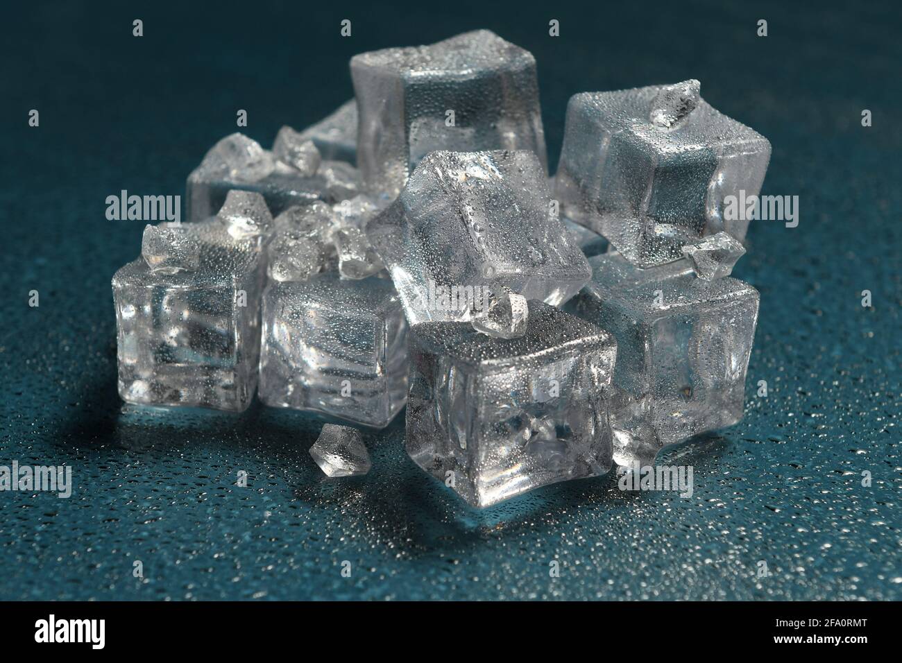 ice stone on reflective surface of background with drops, idea of a ...