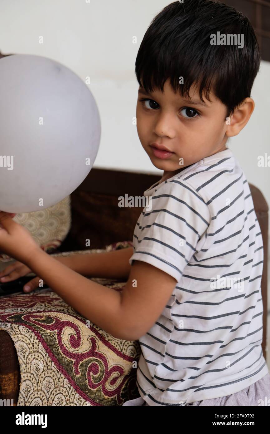 Shallow focus of an Indian kid playing with a balloon in a house Stock ...