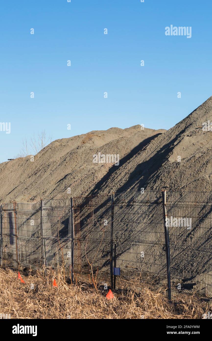 Security fence guarding piles of excavated earth at construction site ...