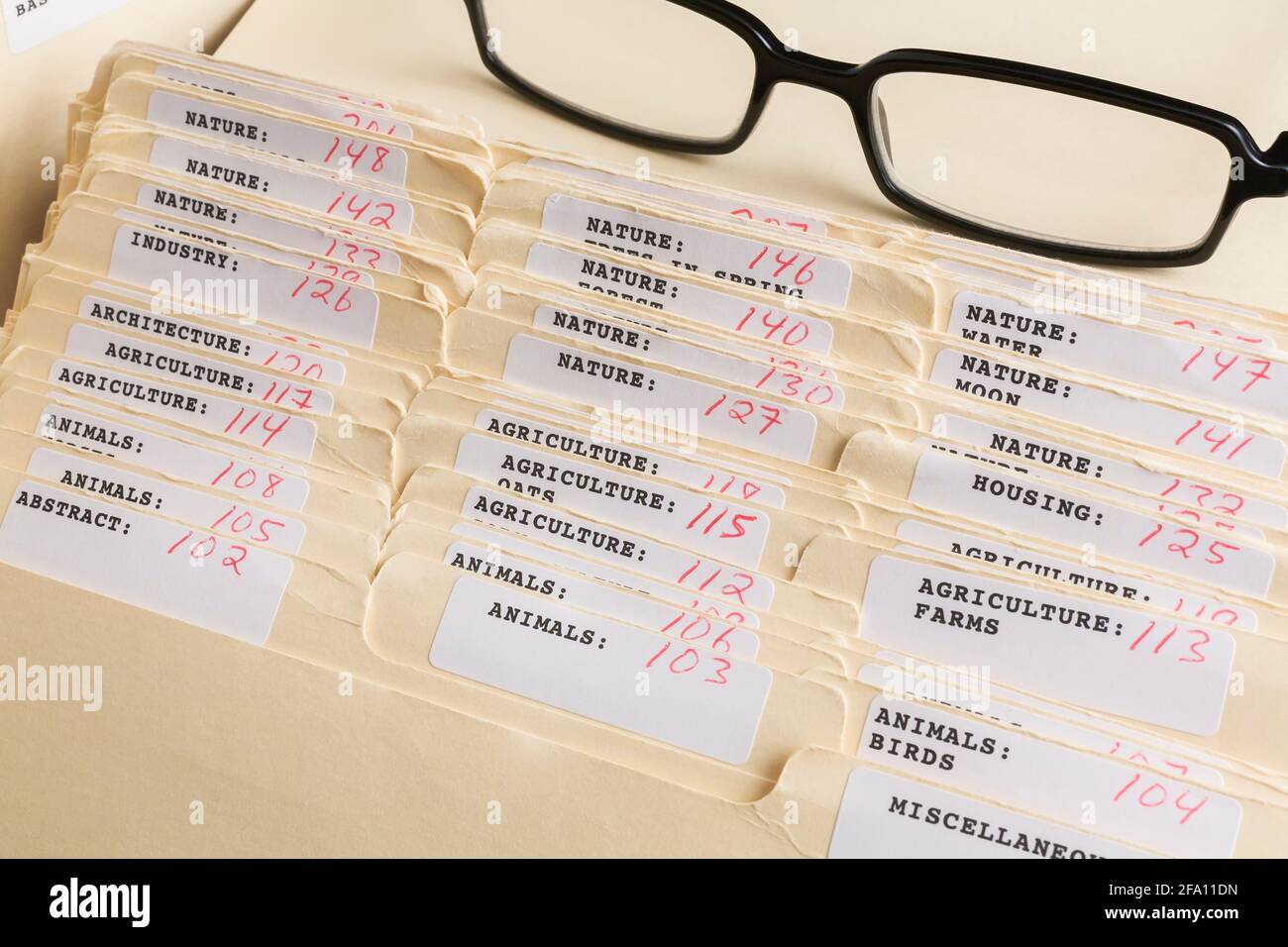 Black frame reading glasses on top of alphabetically arranged cardboard ...