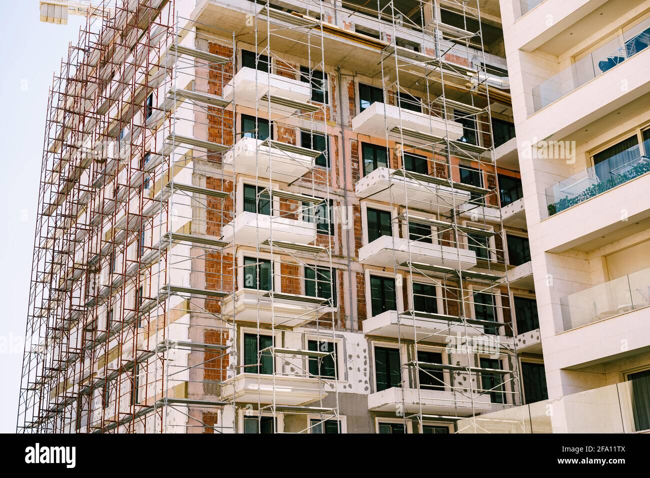Scaffolding around a modern high-rise building under construction Stock ...