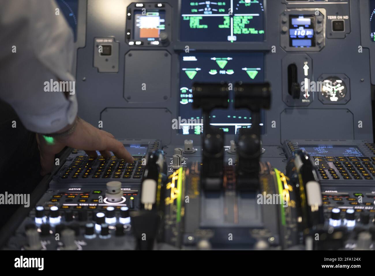 Hand of the airplane pilot pushing a button in the cockpit of a ...
