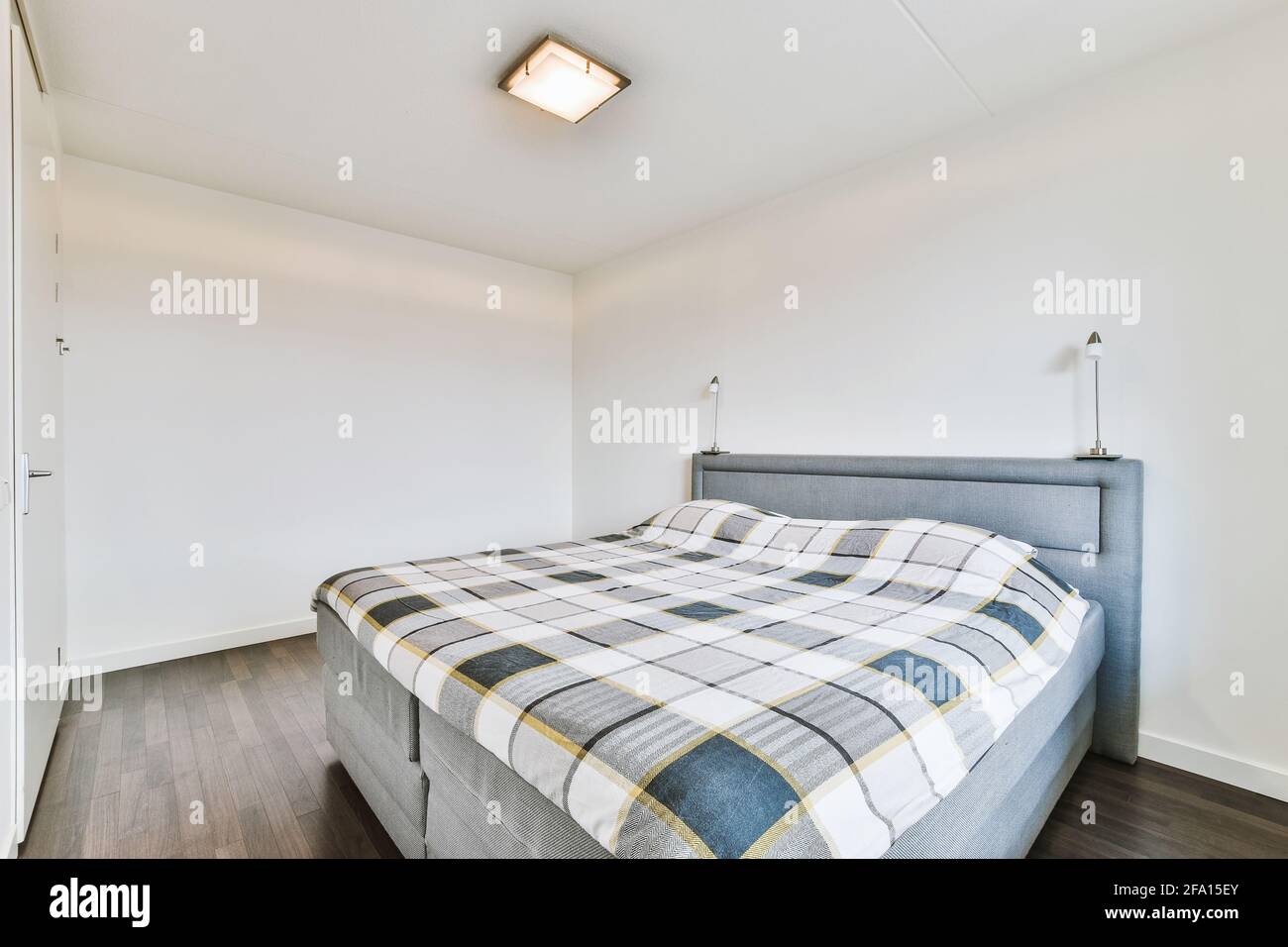 Wide bed in light bedroom Stock Photo - Alamy