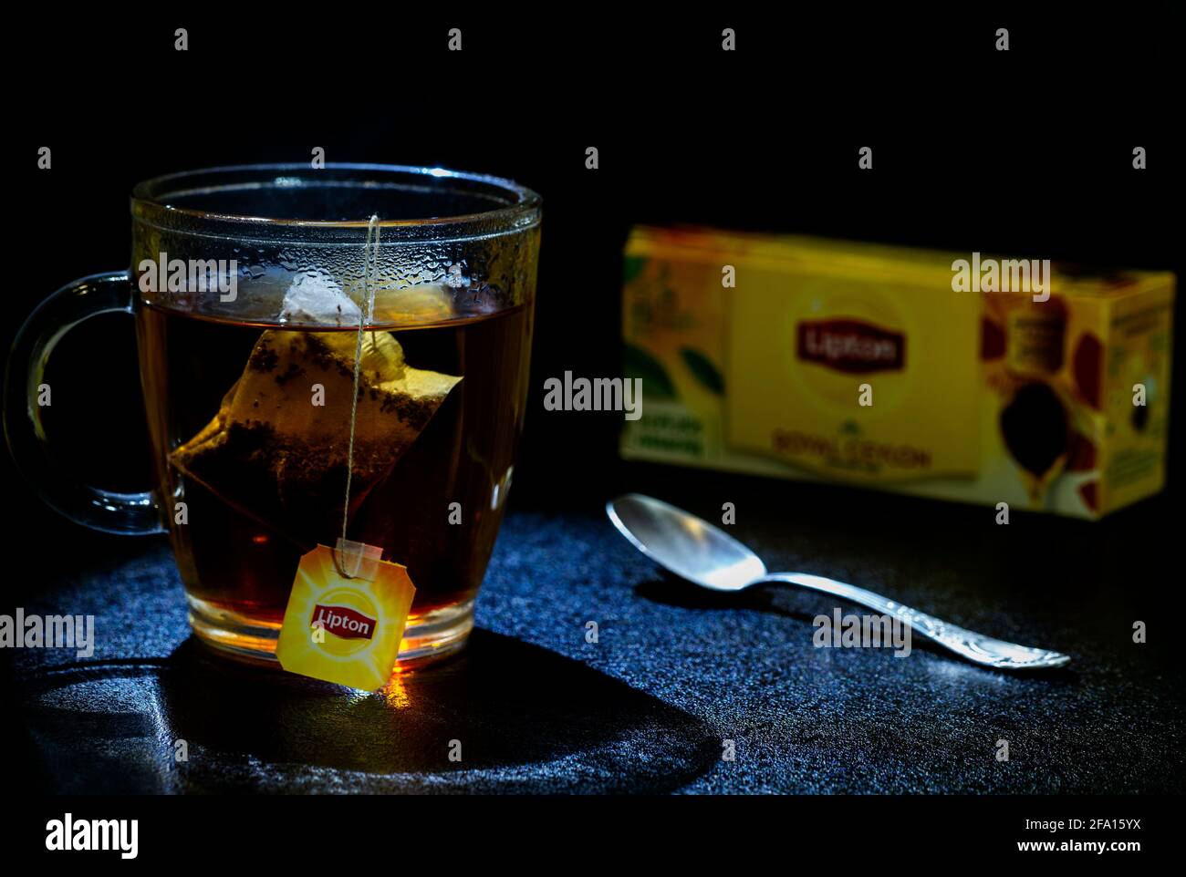 Lipton tea cup and cardboard packaging of tea on a black background ...