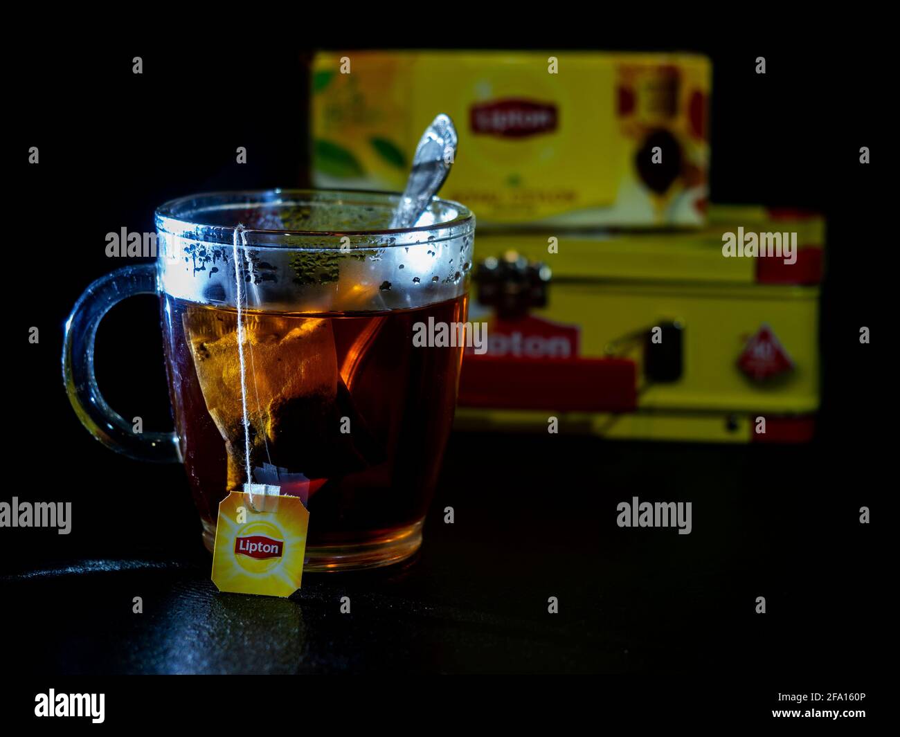 Lipton tea cup, metal and cardboard packaging of tea on a black ...