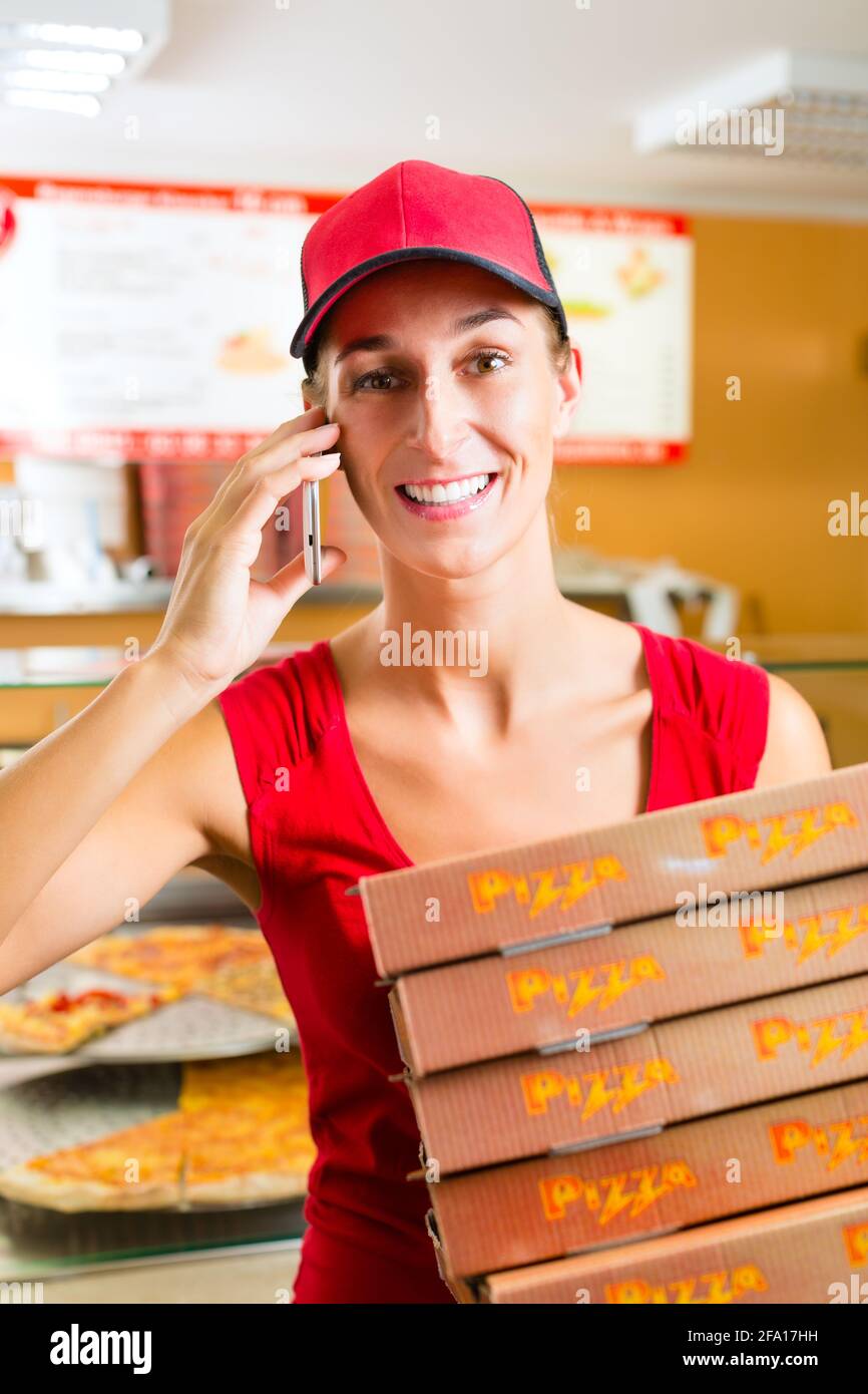 Woman Working As Delivery Girl In A Pizza Place Holding Several Pizza