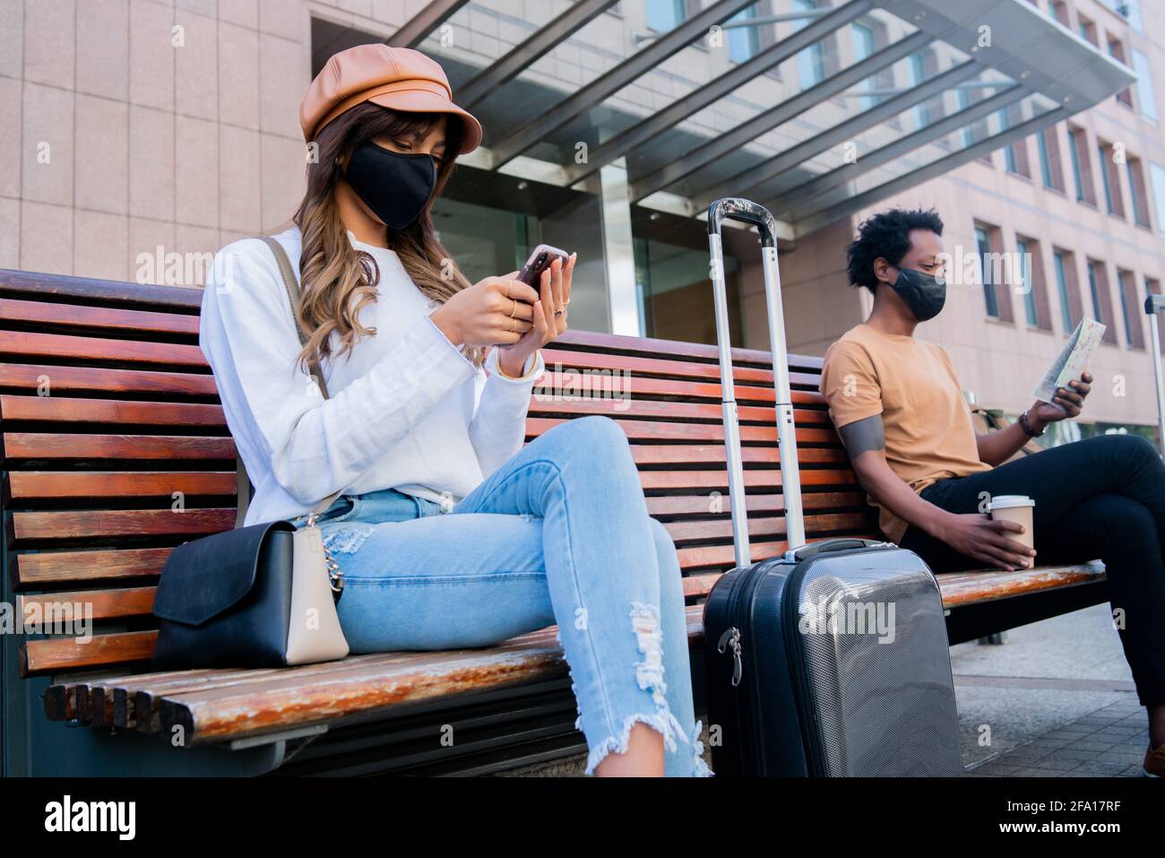 Tourist people waiting outside airport or train station Stock Photo - Alamy