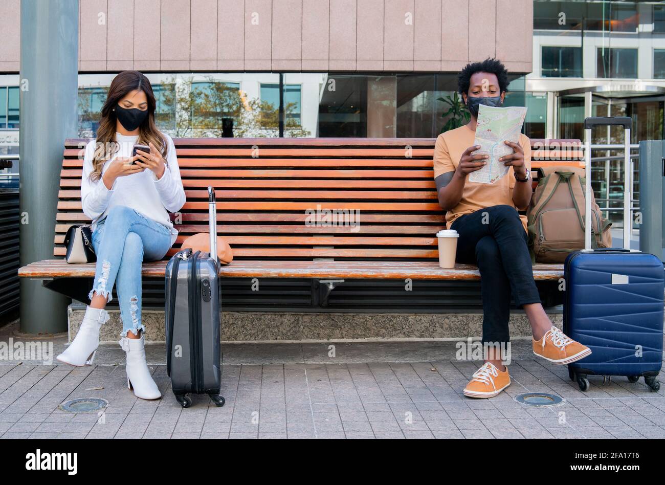 Tourist people waiting outside airport or train station Stock Photo - Alamy