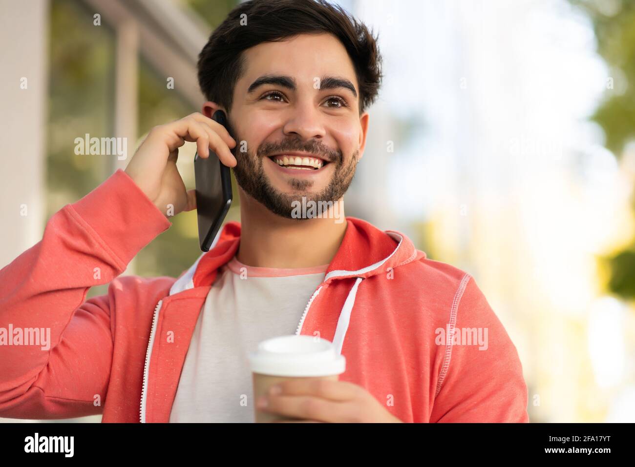 Young man talking cellphone drinking hi-res stock photography and ...