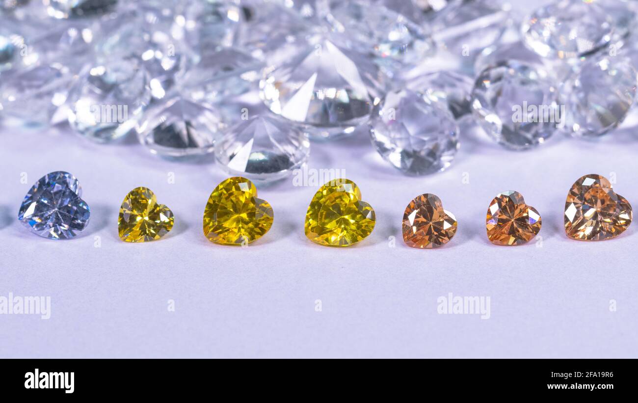 colorful diamond in heart shape are placed in a row on white diamonds ...