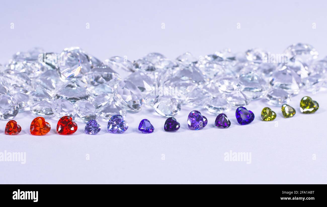 colorful diamond in heart shape are placed in a row on white diamonds ...