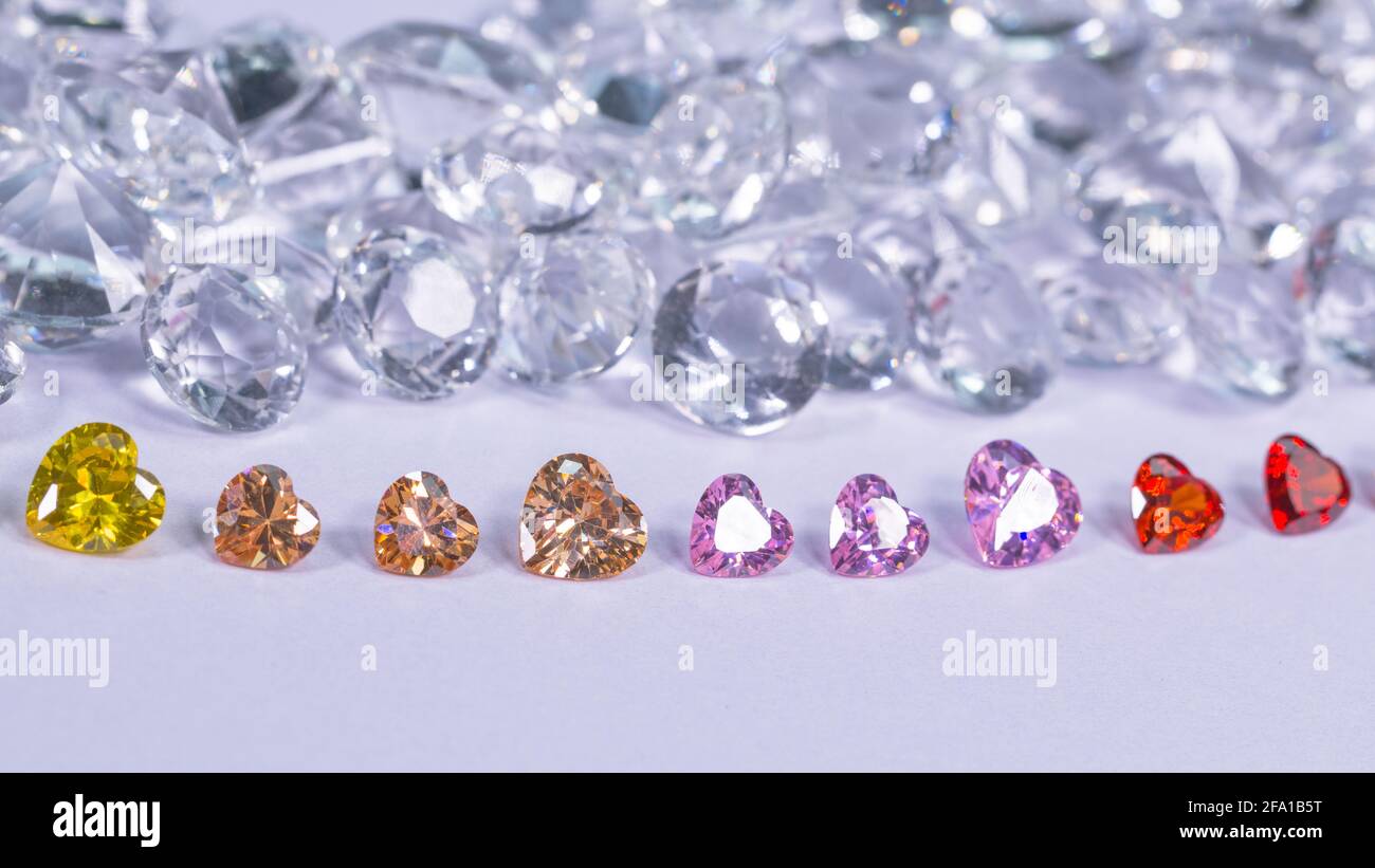 colorful diamond in heart shape are placed in a row on white diamonds ...