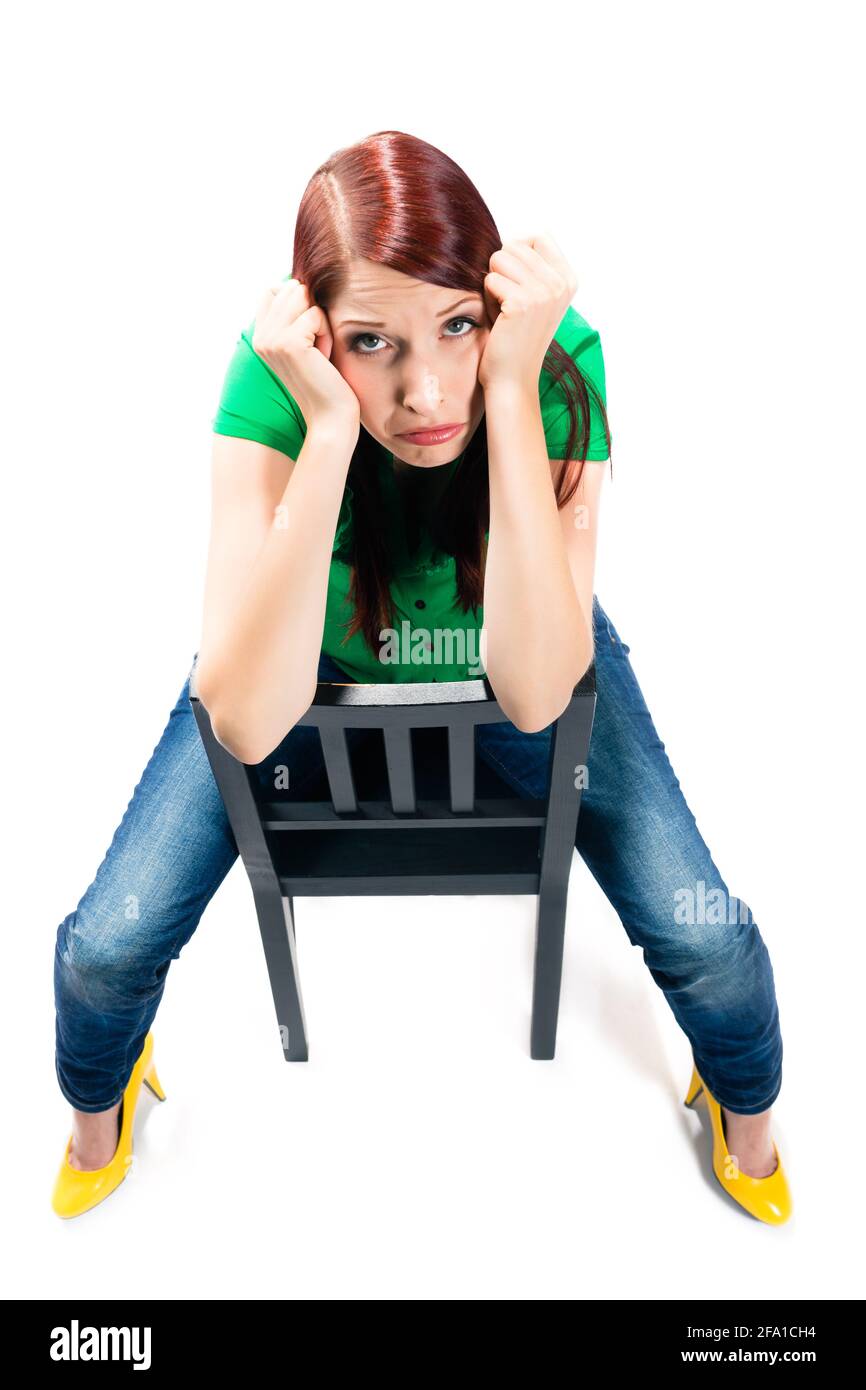 Woman is sitting on a Chair in the Studio and is demotivated or ...