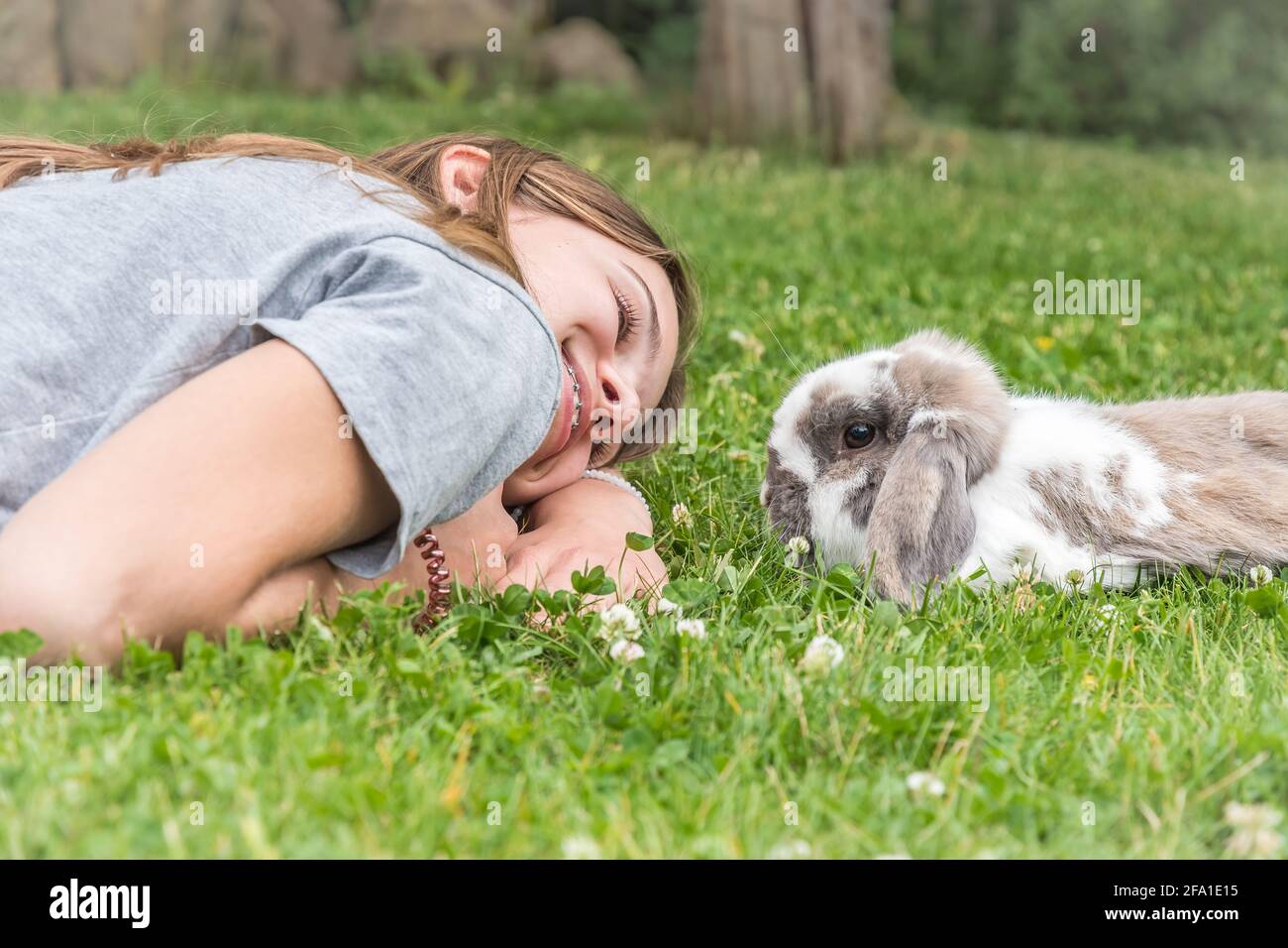 Teenager lying with her rabbit in the green grass Stock Photo - Alamy