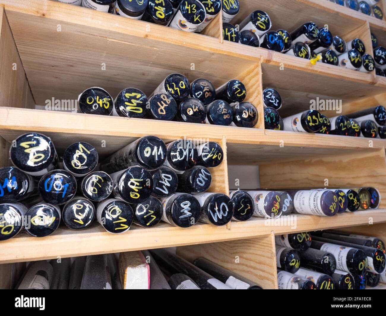 Glass pressing rods. Stack of bunch of colorful glass rods on shelf in ...