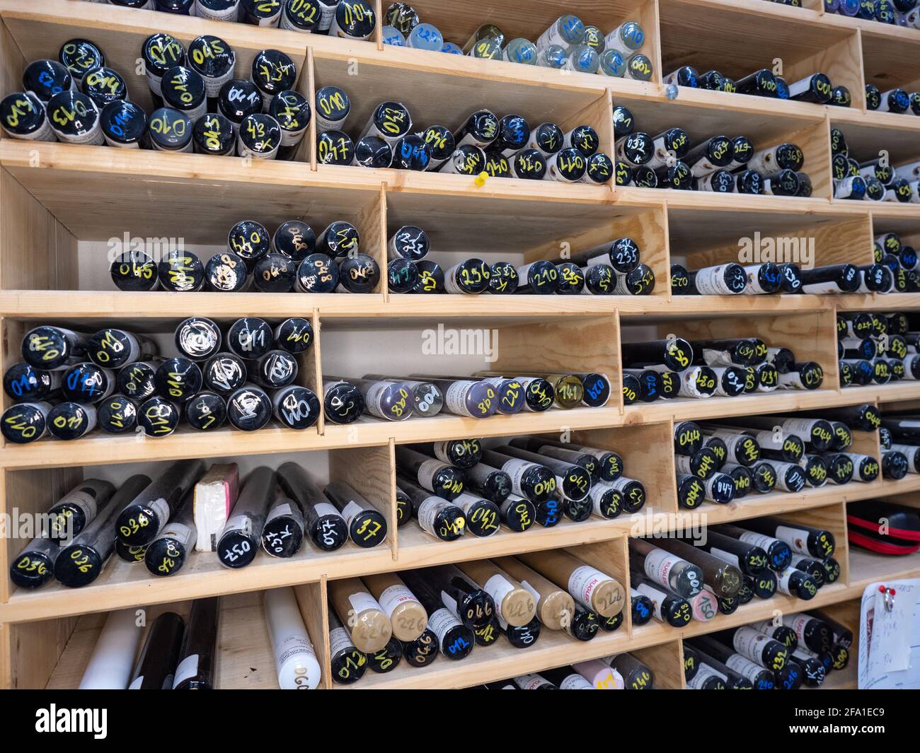 Glass pressing rods. Stack of bunch of colorful glass rods on shelf in ...