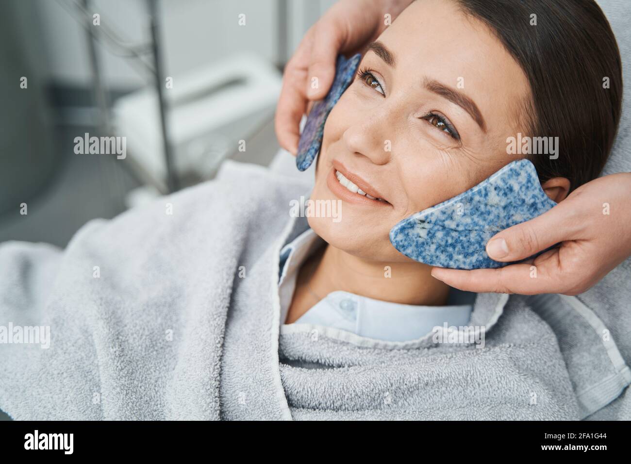 Beautiful spa client enjoying the gua sha treatment Stock Photo - Alamy
