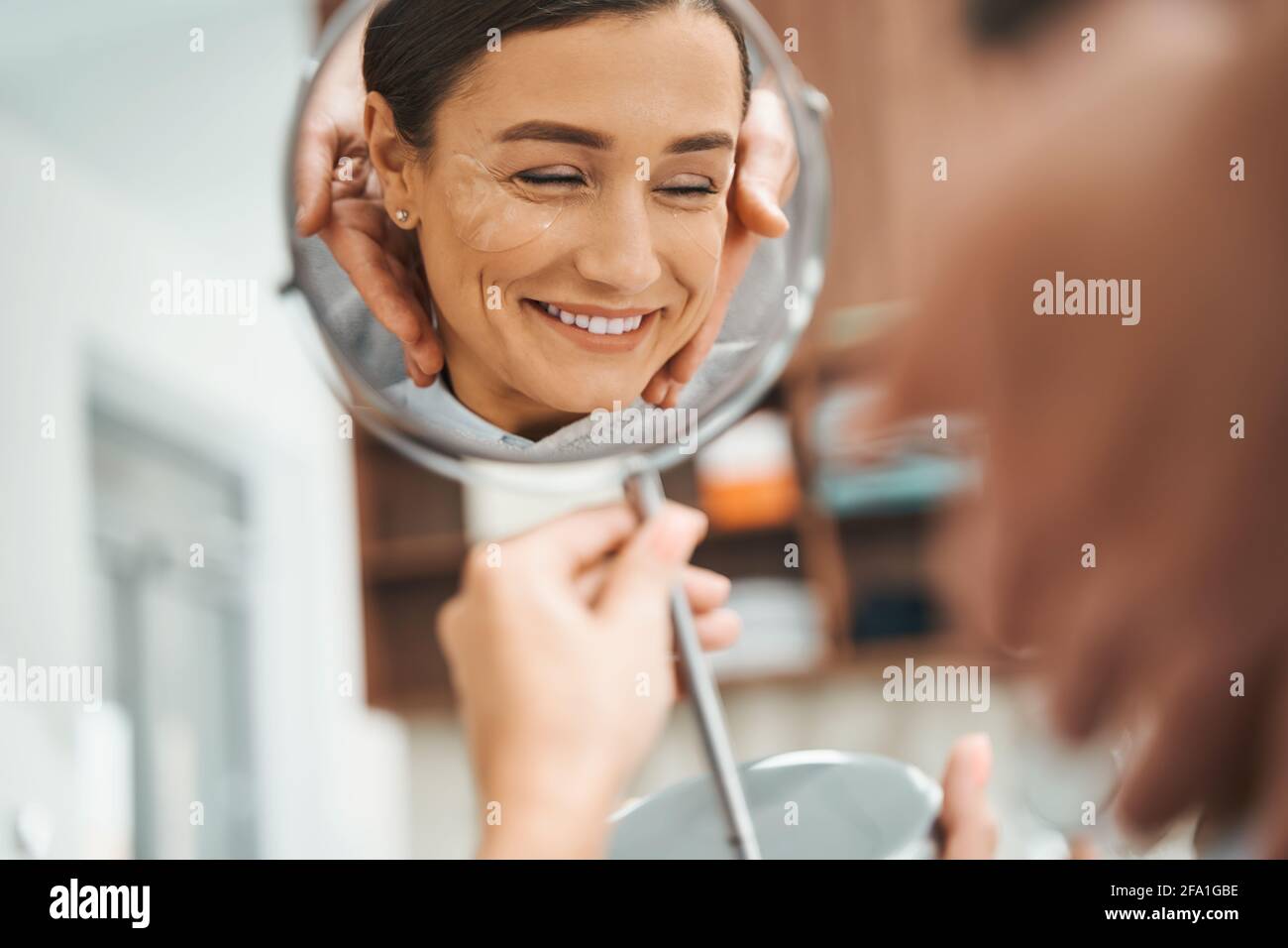 Smiling pleased spa client with a handglass Stock Photo - Alamy