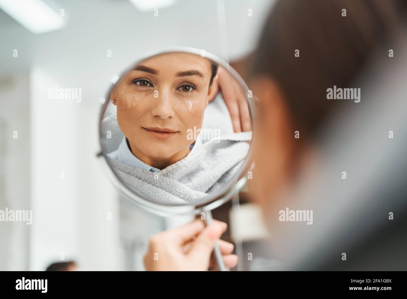 Serious concentrated woman staring at herself in the mirror Stock Photo ...
