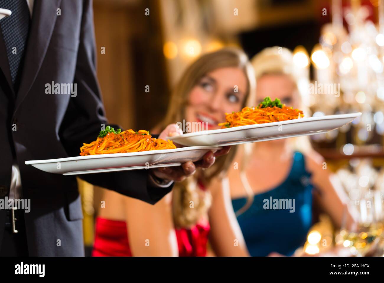 Good friends for lunch in a fine restaurant, waiter served the dinner ...