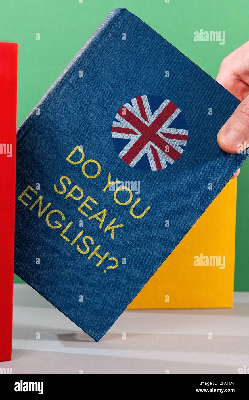 A man's hand holds an blue English textbook. Close-up. English Language ...