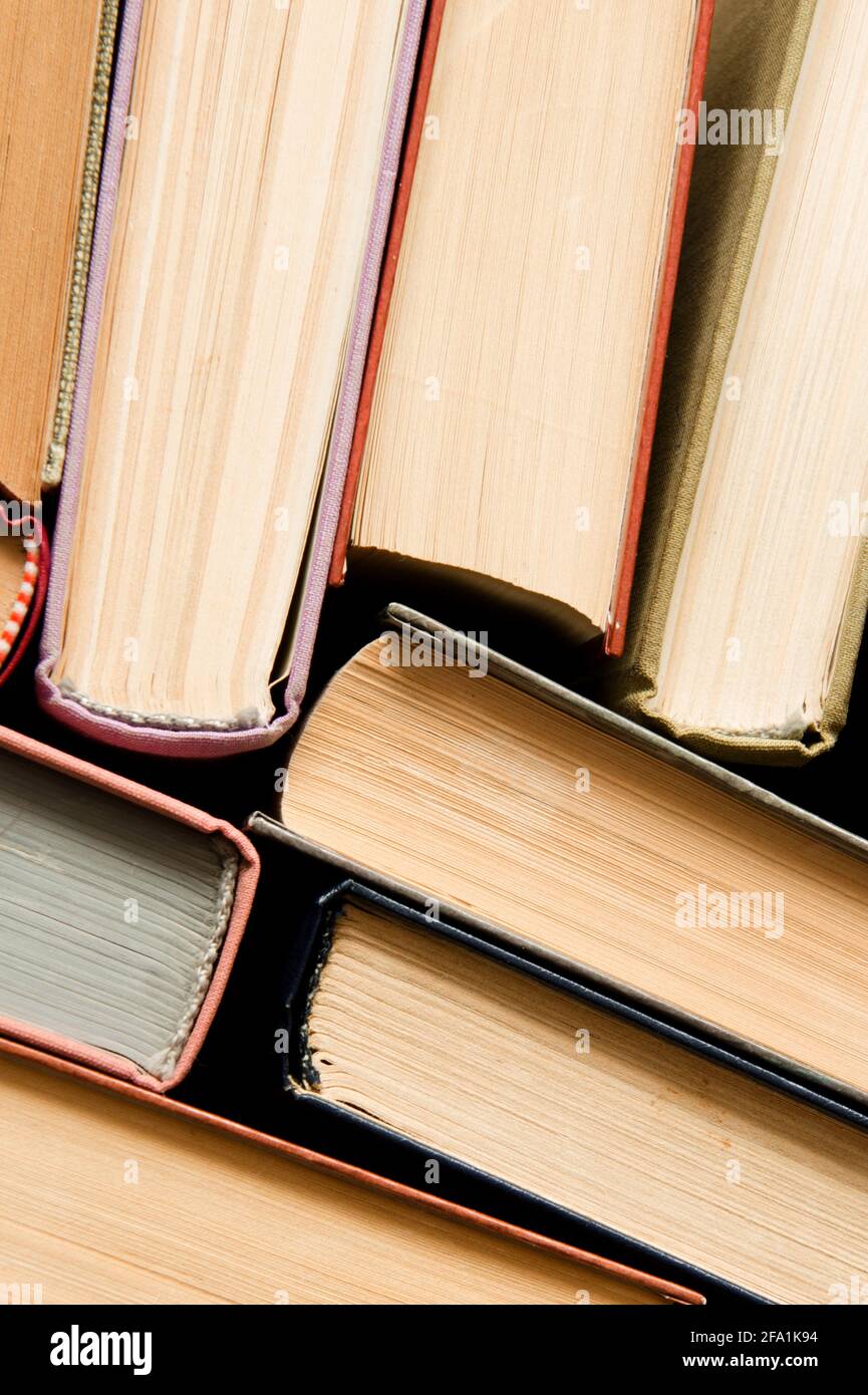 A stack of colorful books in a library or a room. Many multi-colored ...