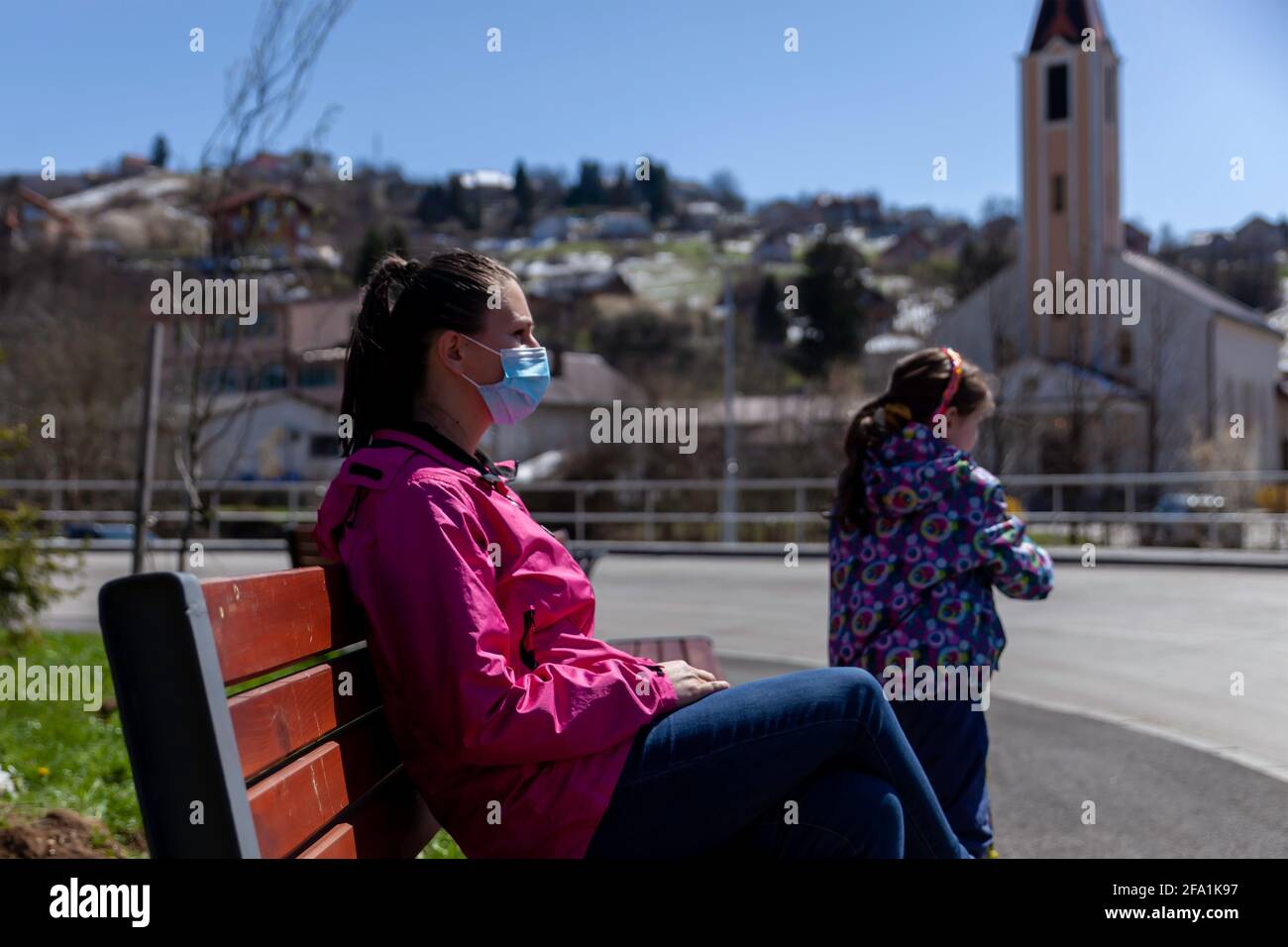 A young mother with a female child at a bus stop Stock Photo - Alamy