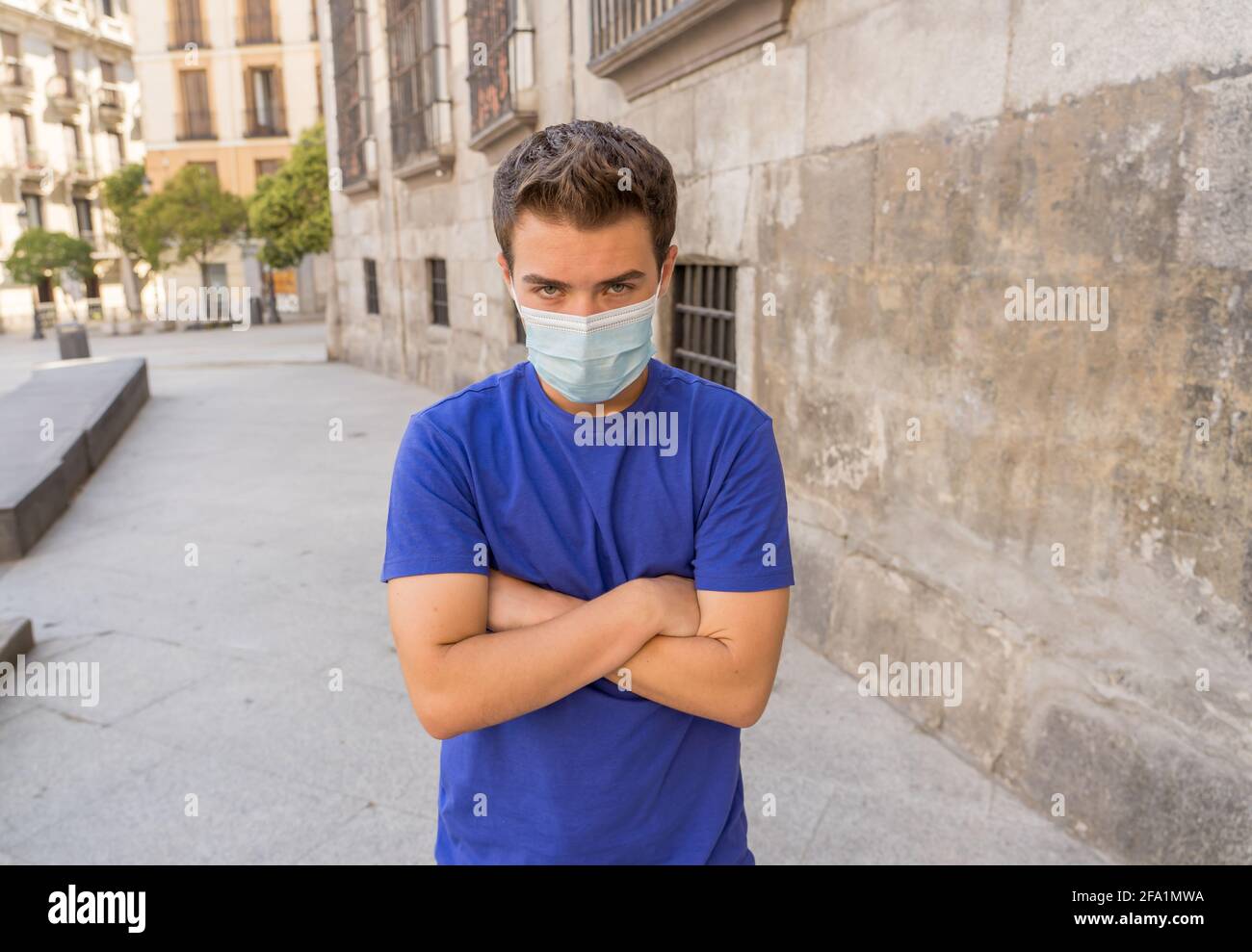 Young sad desperate man wearing surgical face mask in public spaces ...