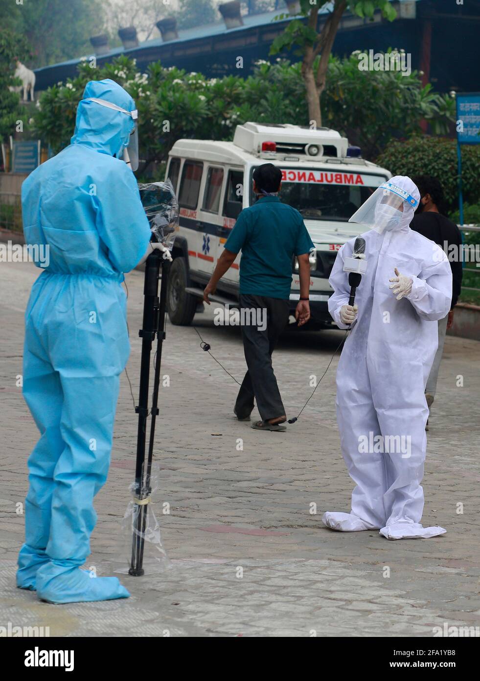 A journalist is seen wearing a personal protective equipment suit (PPE ...