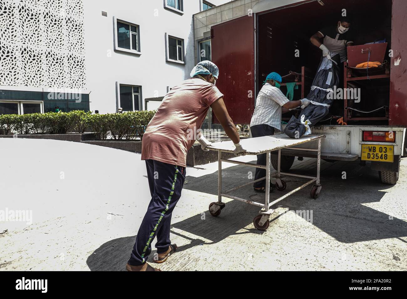 (EDITORS NOTE: Image depicts death) Health workers carry a COVID-19 ...