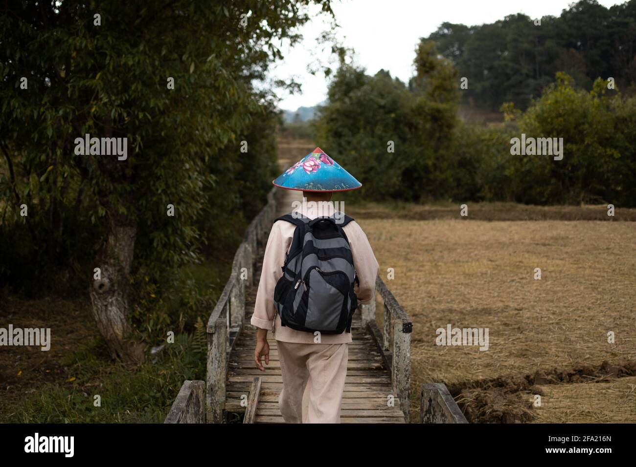 Burmese man in traditional clothing and a colorful blue hat trek a ...