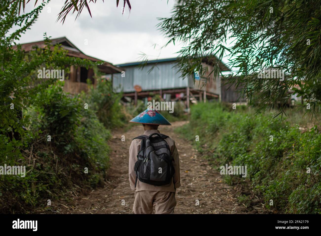 Burmese man in traditional clothing and a colorful blue hat trek ...