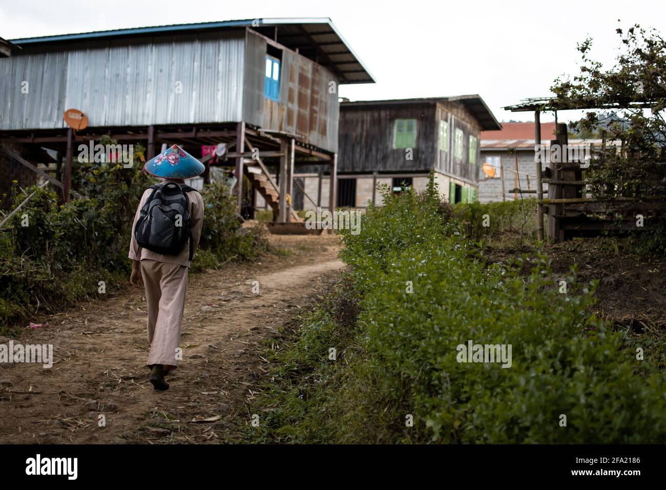 Burmese man in traditional clothing and a colorful blue hat trek ...