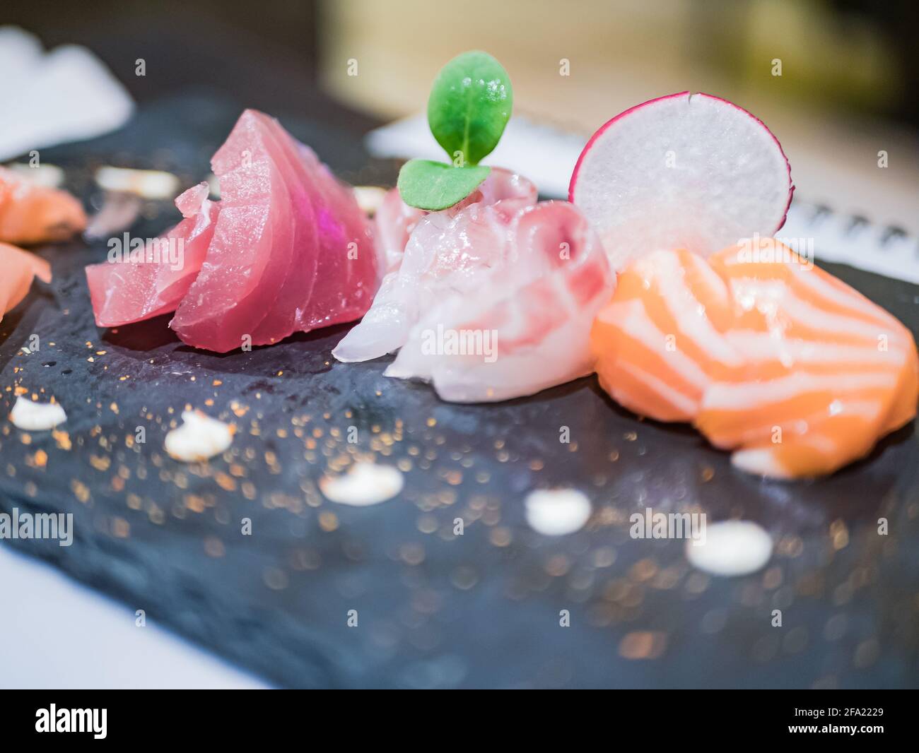 Close-up of a typical Japanese dish of sushimi with tuna salmon roll on ...