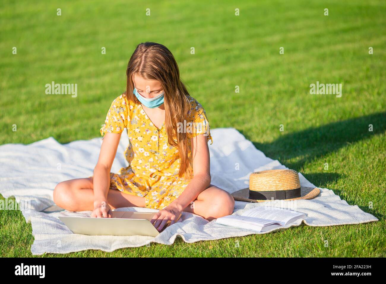 Little girl outdoors in the park with computer Stock Photo - Alamy