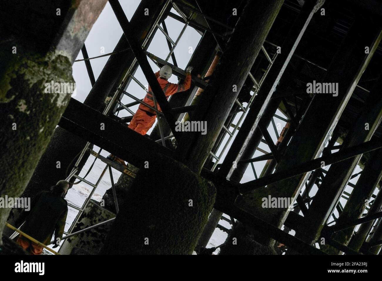 Engineer working on old pier during low tide hi-res stock photography ...