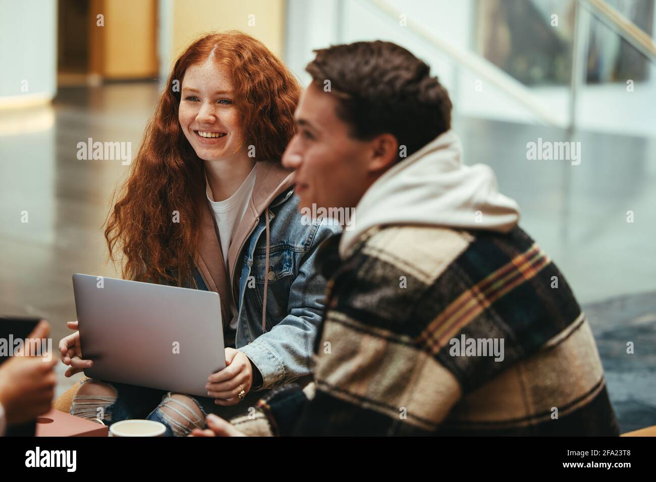 Friends studying together at university. Students sitting together and ...