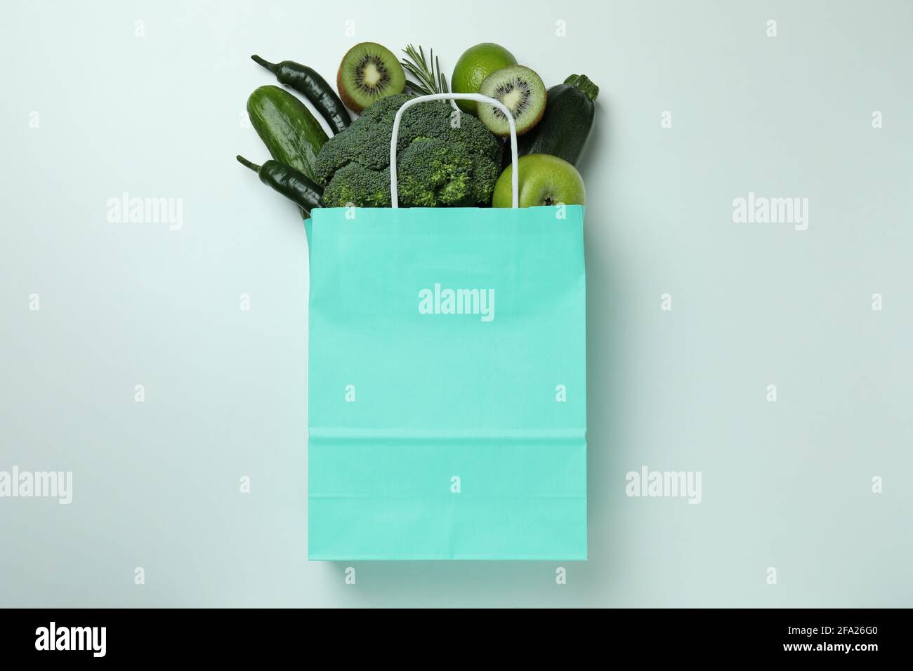 Paper bag with green vegetables on white background Stock Photo - Alamy