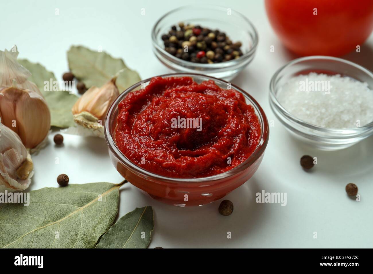 Bowl with tomato paste on white background with ingredients Stock Photo ...