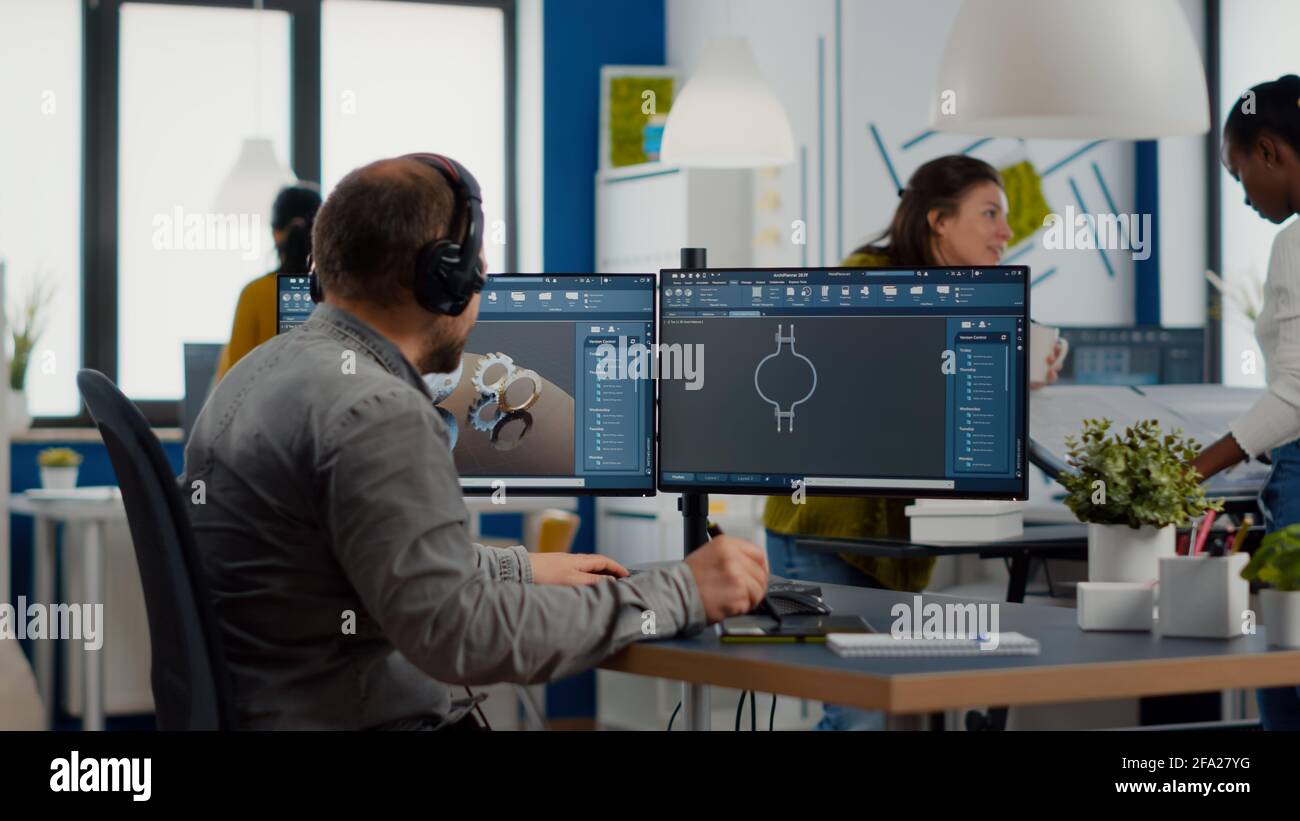 Engineer with headset working on PC, screen showing CAD software with ...