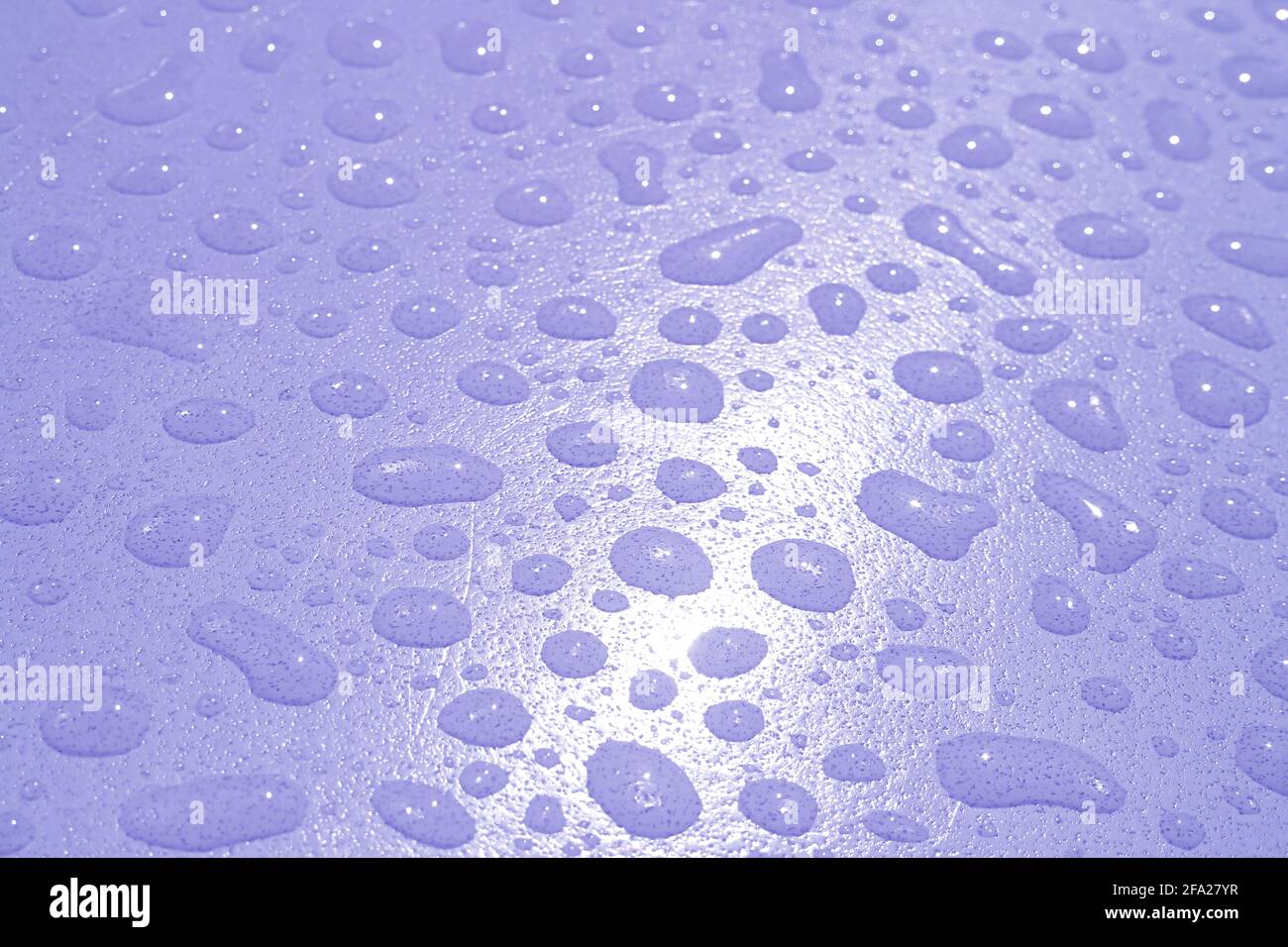 Pop art style pastel lavender colored water droplets on the tabletop ...