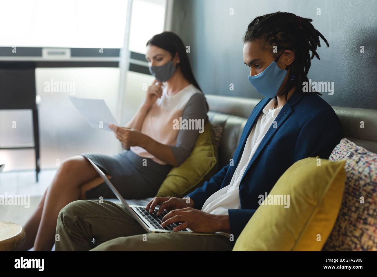 Diverse male and female of business colleagues wearing face masks ...
